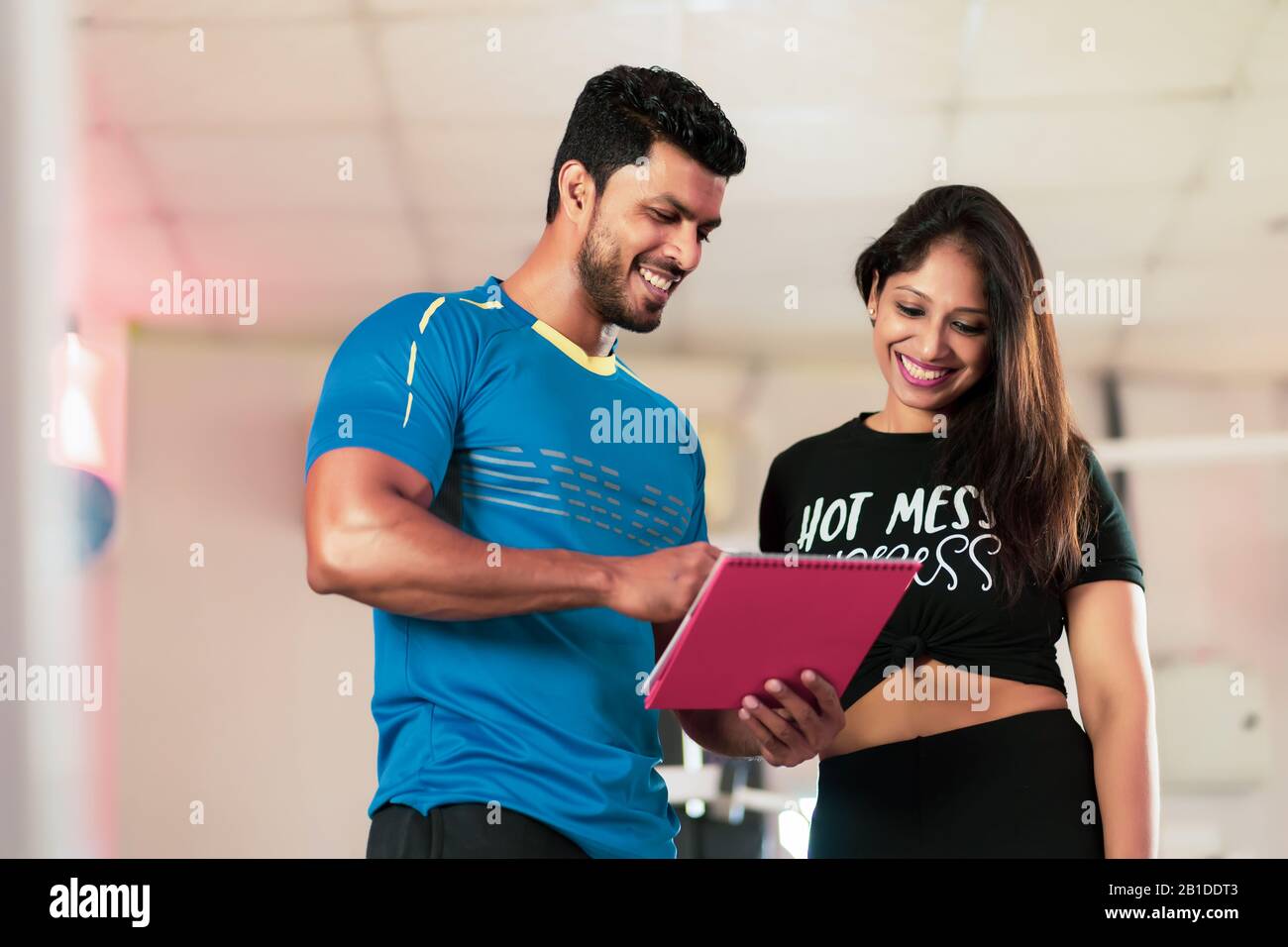 Handsome personal trainer speaking with his client at the gym Stock ...