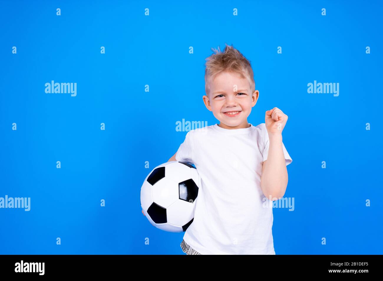 Soccer fans. Smiling caucasian child boy holding soccer ball in hands ...