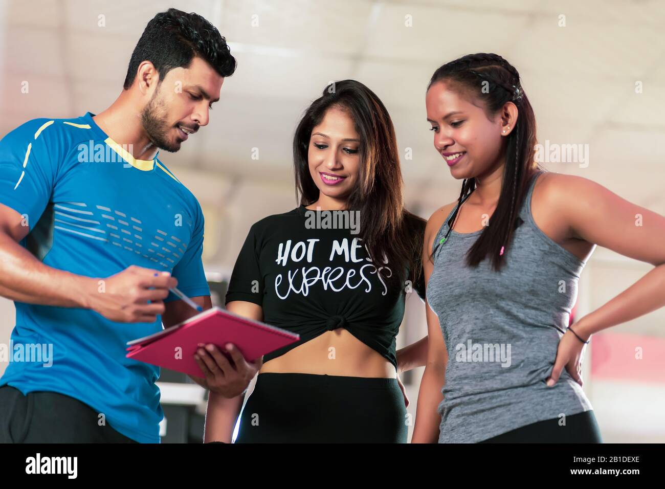 Handsome personal trainer speaking with his client at the gym Stock ...