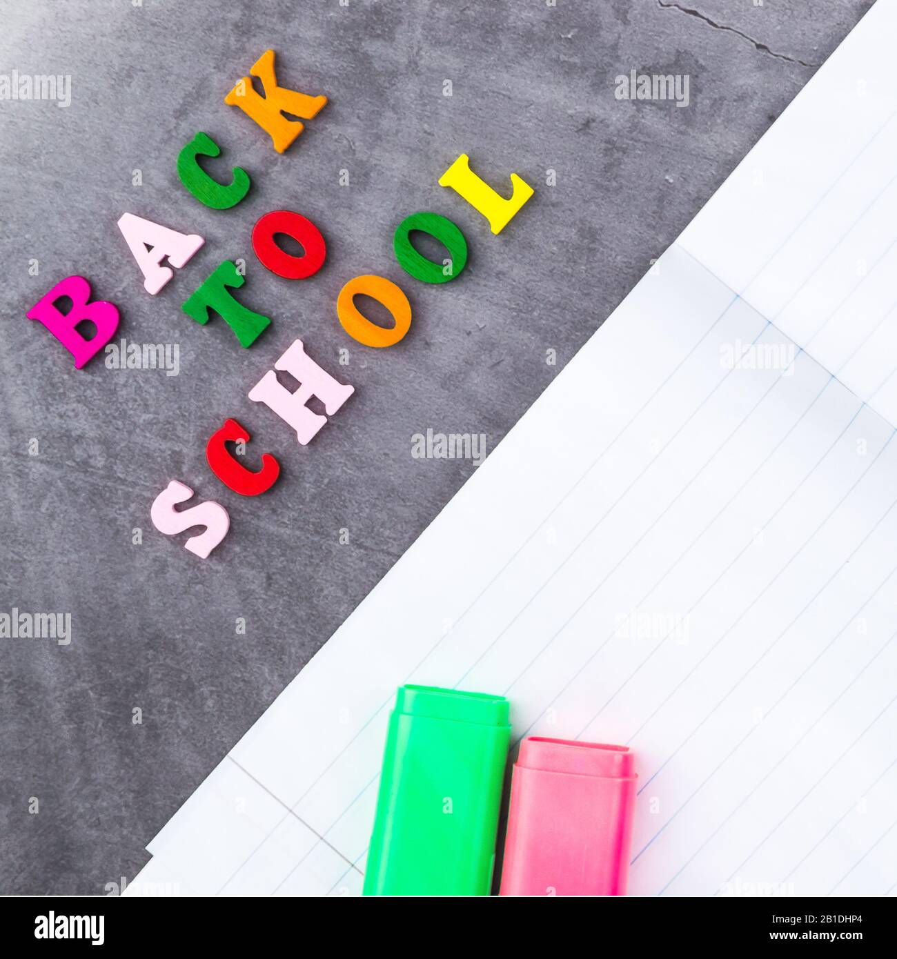 The layout of school supplies on a dark gray background. Top view, the ...