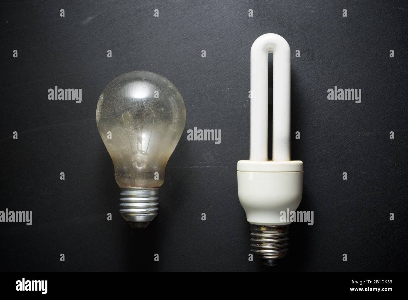 An old incandescent bulb and a modern bulb on a black table Stock Photo ...