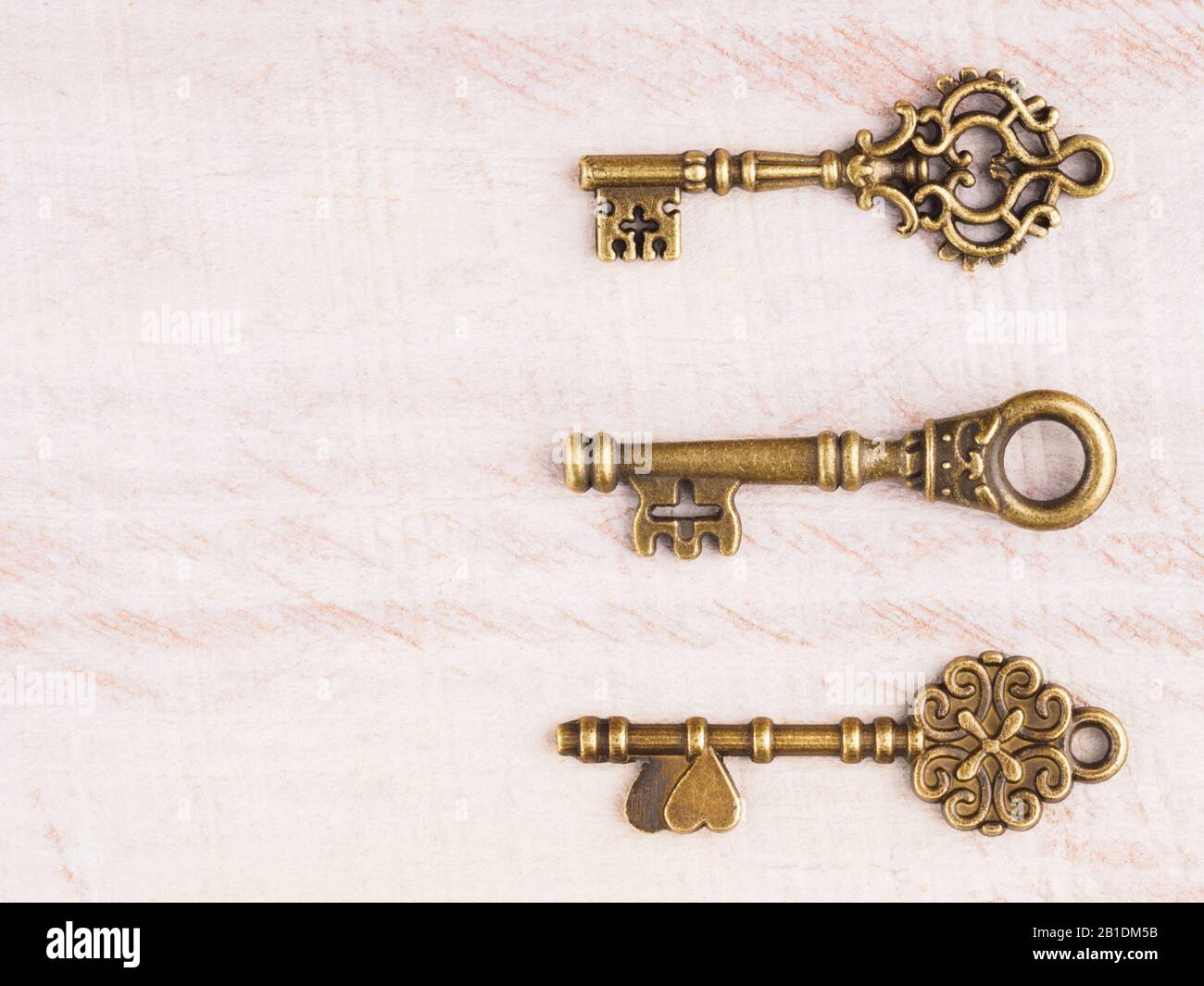 Set of antique keys on light brown wooden background Stock Photo - Alamy