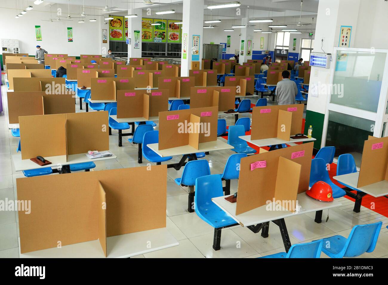 Chinese workers eat lunch alone and separately in the canteen at the ...
