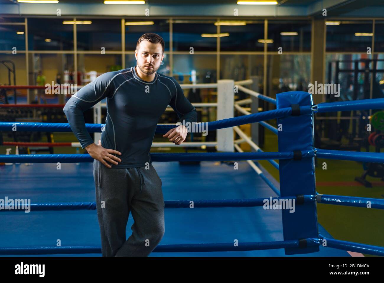 portrait of a young sports guy in the gym. man stands on the boxing ...