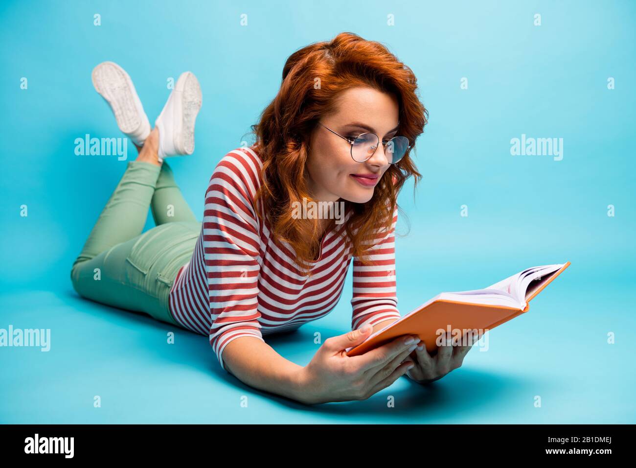 Full body close up photo of positive girl lying floor read poems enjoy ...