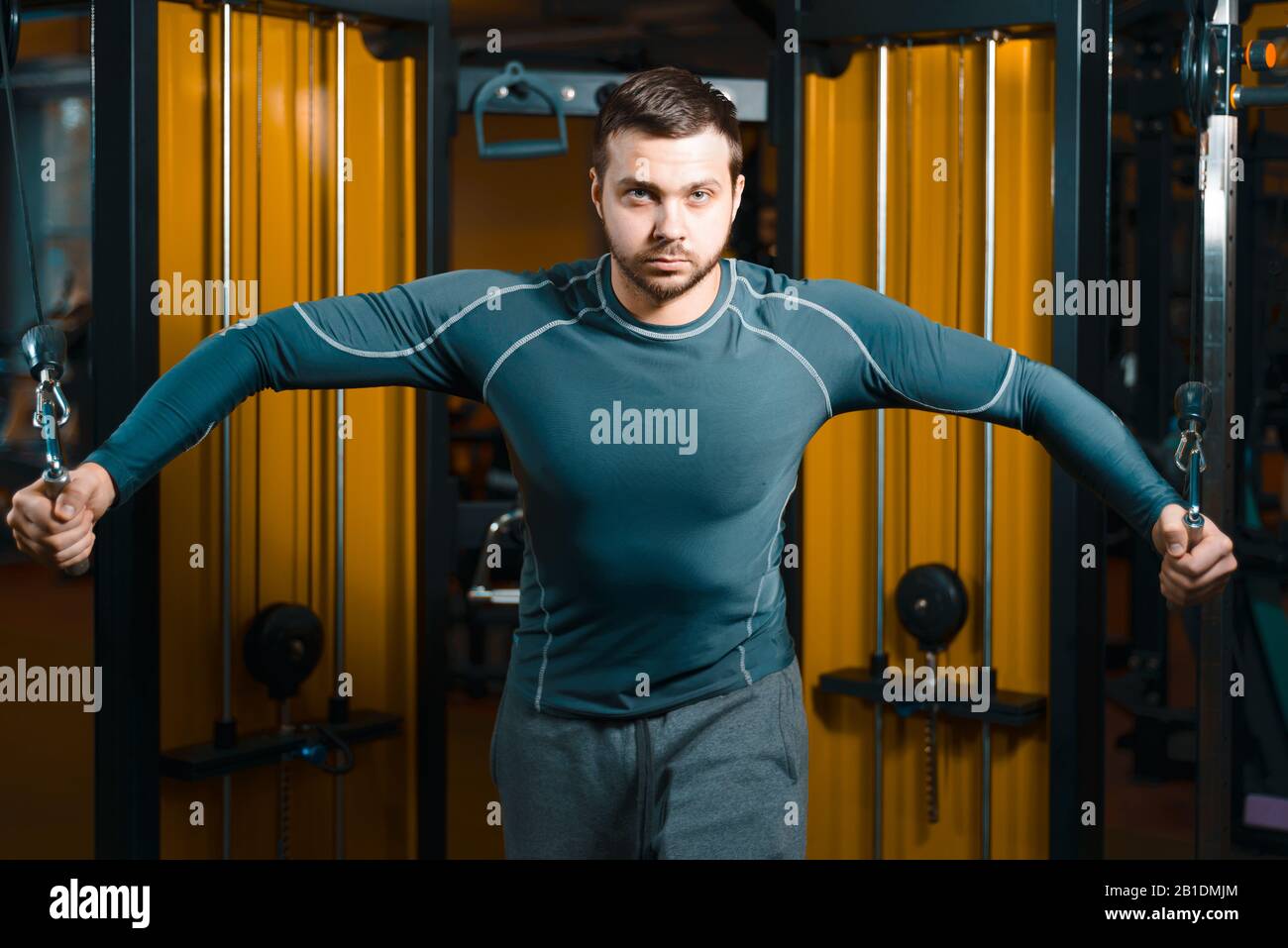 young guy training on simulators in the gym Stock Photo - Alamy