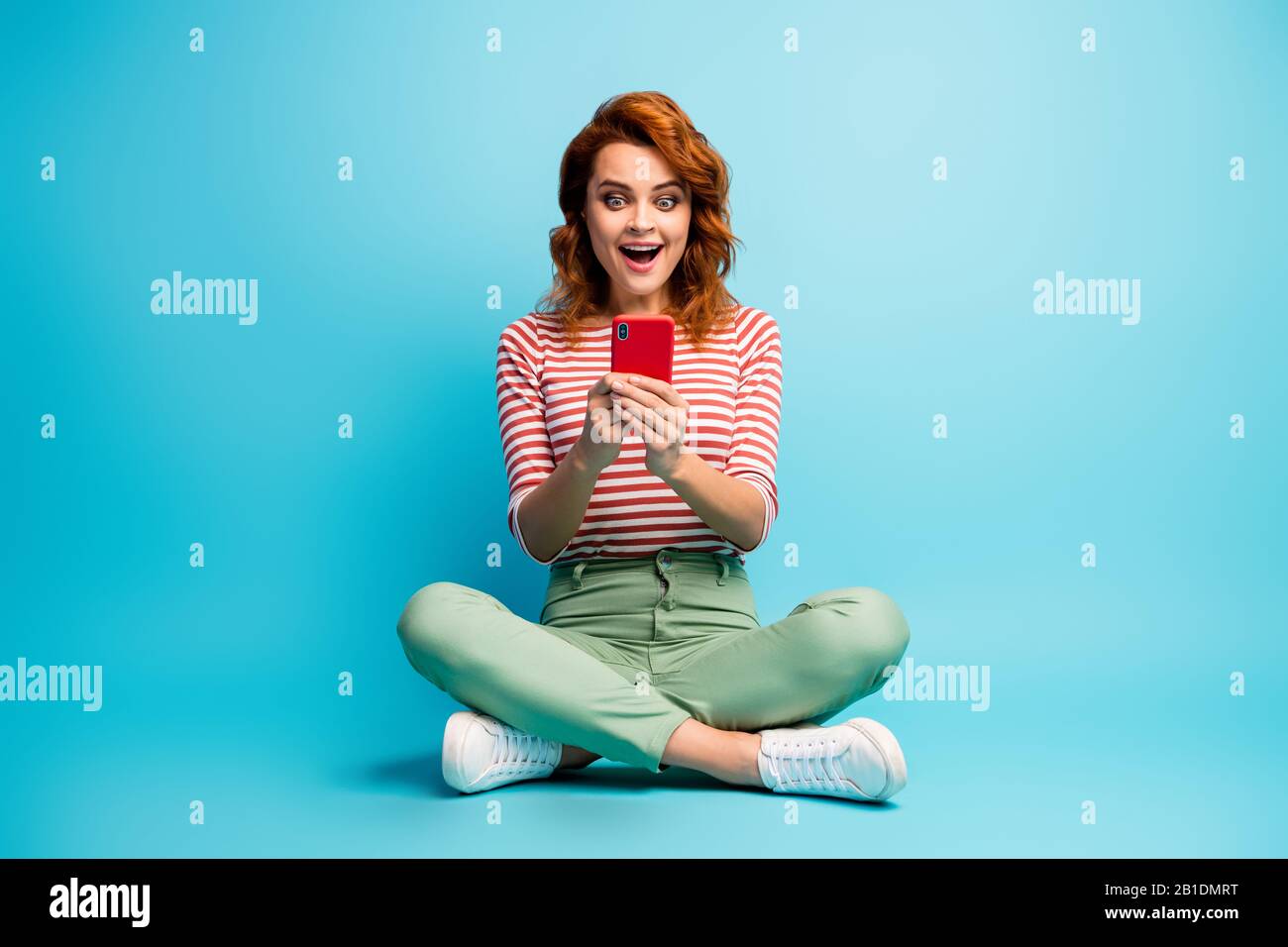 Full length photo excited addicted woman sit legs crossed use ...