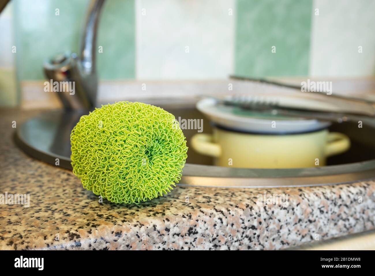 Green plastic mesh scourer, used to clean dishes, plates, pan and pots ...