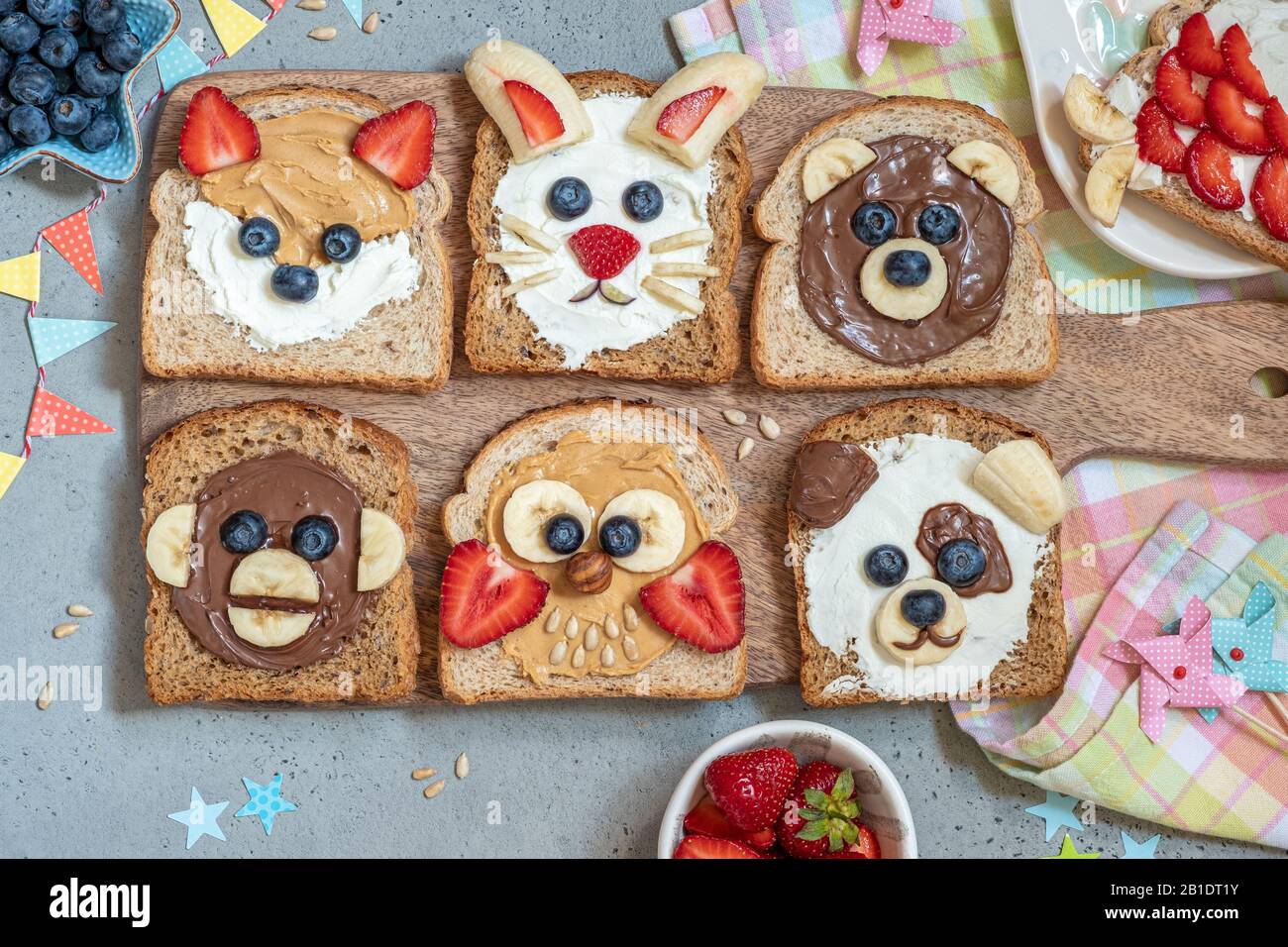 Funny animal faces toasts with spreads, banana, strawberry and ...