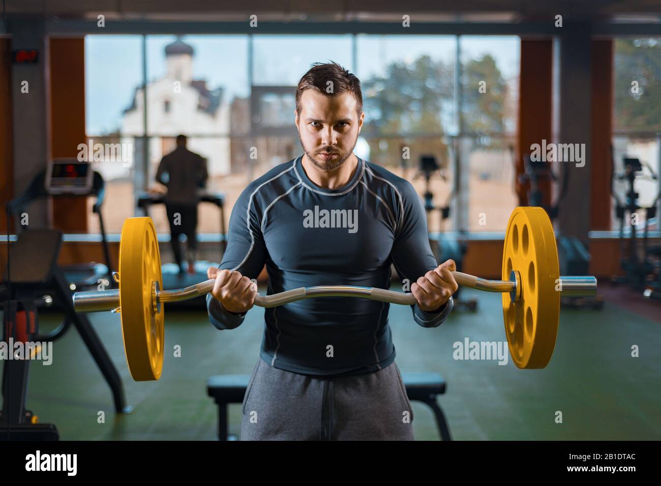 sports guy is training with a barbell. athletic man doing weight in the ...