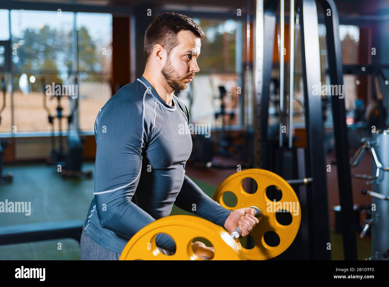 sports guy is training with a barbell. athletic man doing weight in the ...