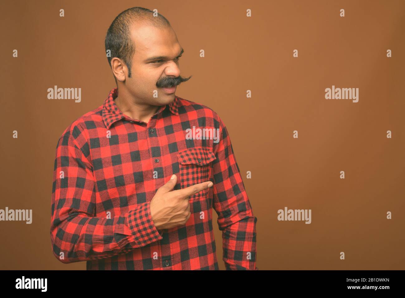 Indian man with mustache against brown background Stock Photo - Alamy