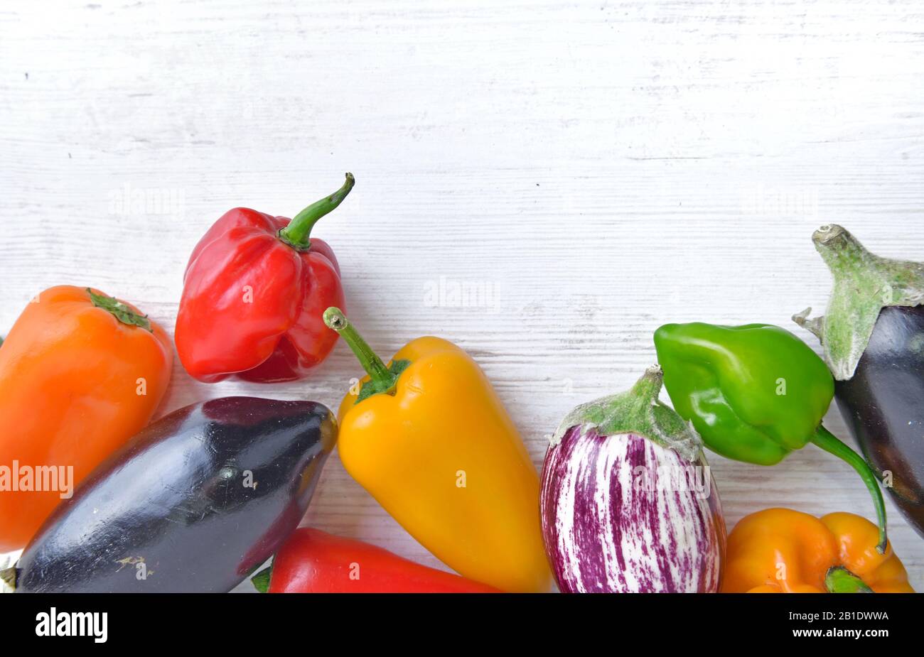 collection of colorful vegetables as peppers and eggplants on a white ...