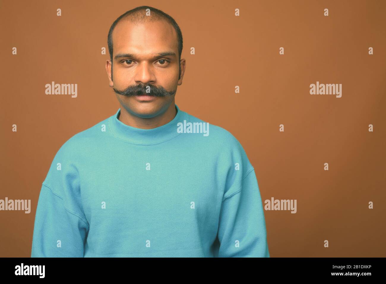 Indian man with mustache against brown background Stock Photo - Alamy