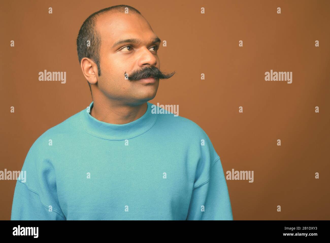 Indian man with mustache against brown background Stock Photo - Alamy