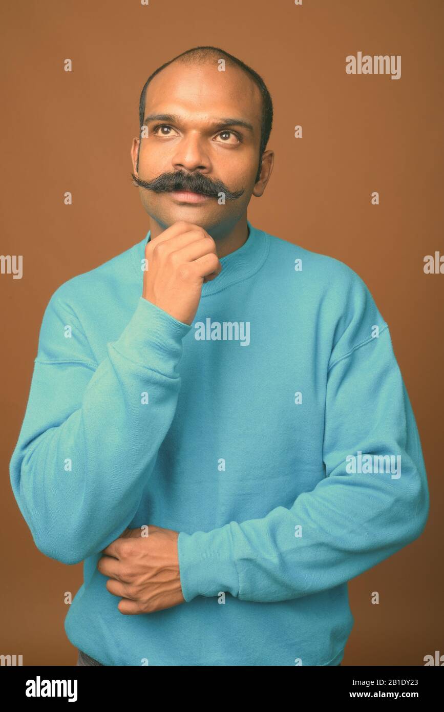 Indian man with mustache against brown background Stock Photo - Alamy