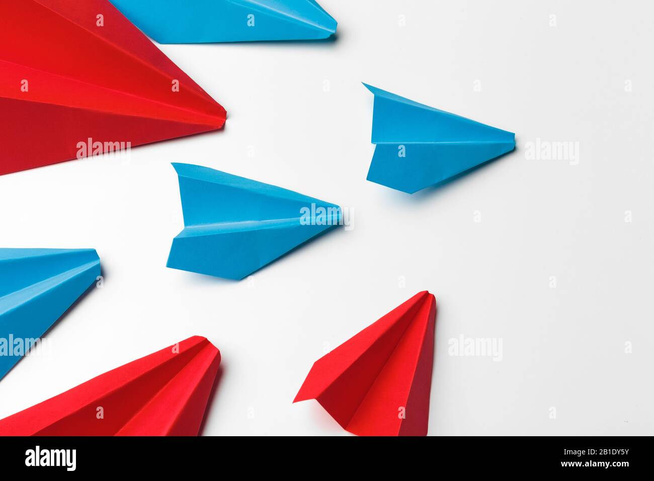 Red and blue paper planes on white background. Leadership and Business ...