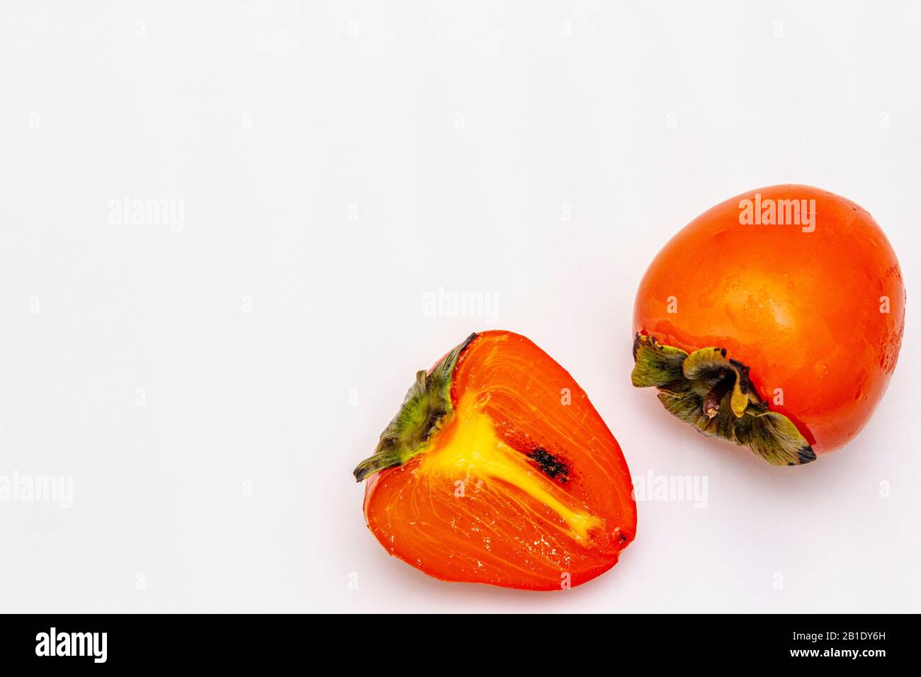 Ripe single persimmon. Fresh whole fruit, half sliced. Isolated on ...
