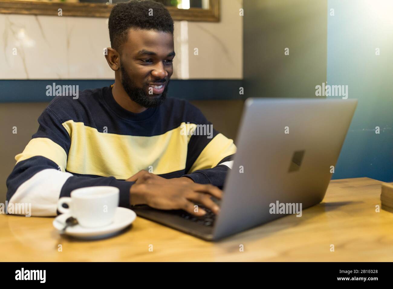 Serious african-american man using laptop studying on computer in ...