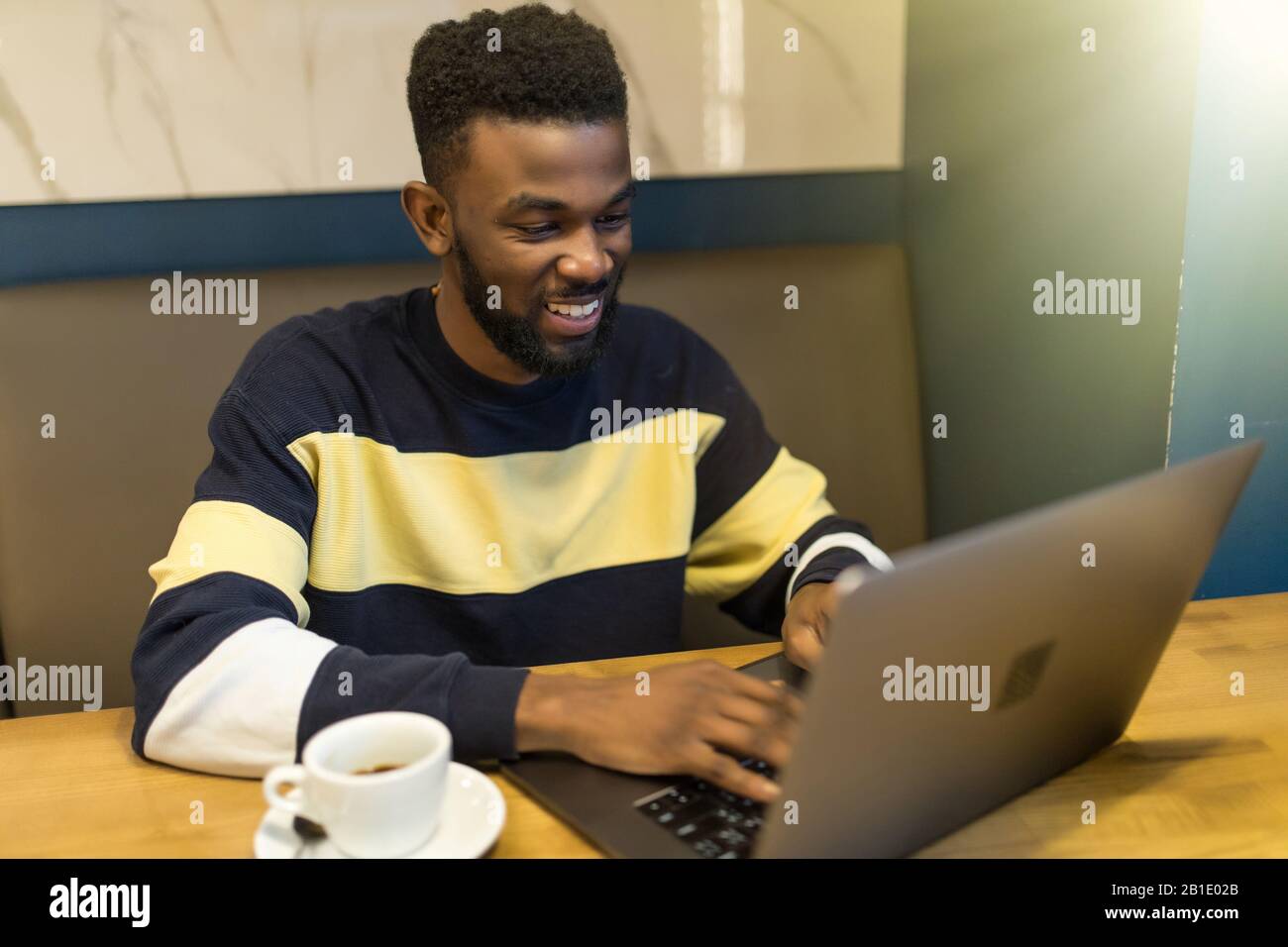 Serious african-american man using laptop studying on computer in ...