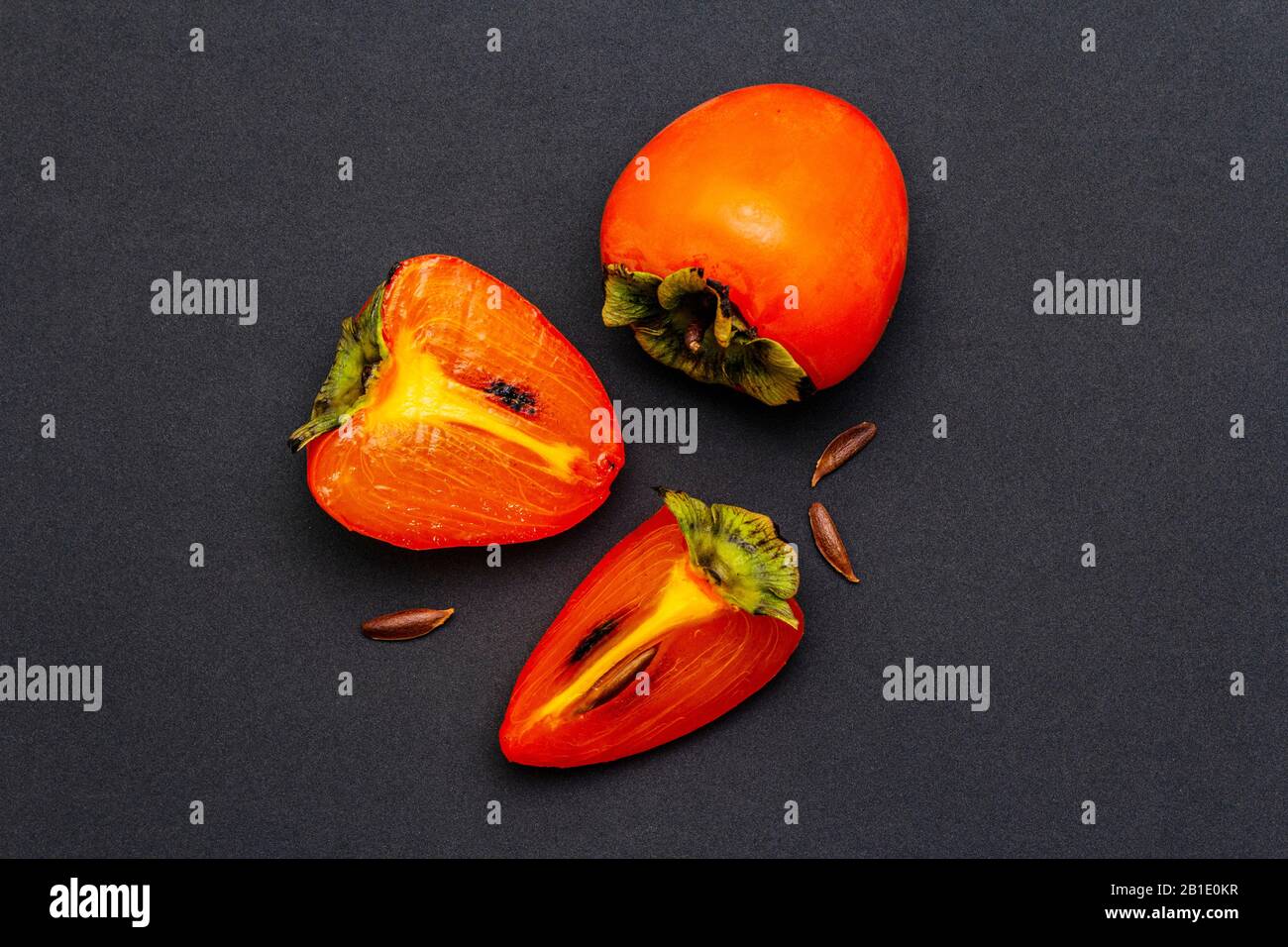 Ripe single persimmon. Fresh whole fruit, half sliced, seeds. Isolated ...