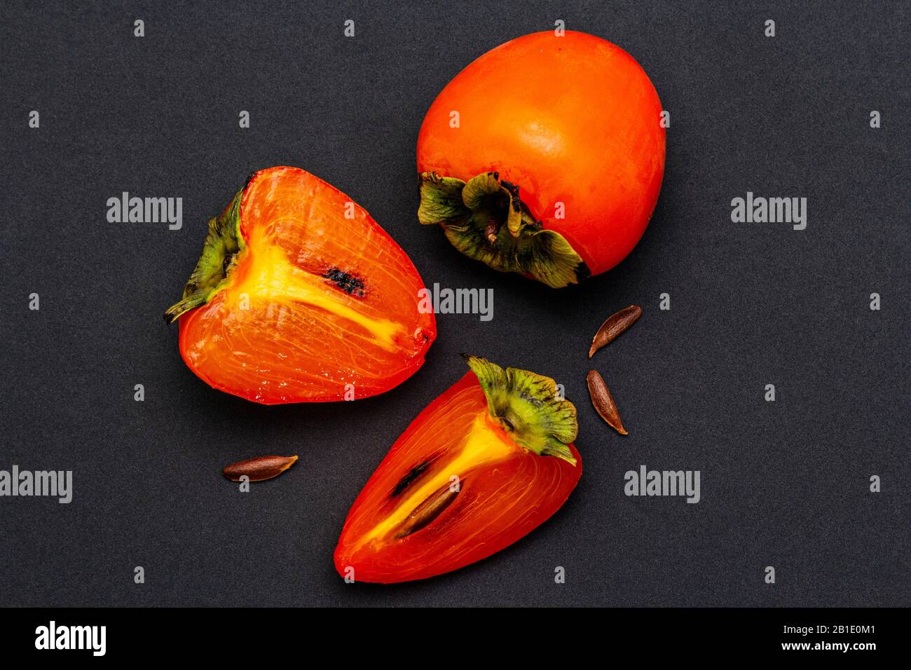 Ripe single persimmon. Fresh whole fruit, half sliced, seeds. Isolated ...