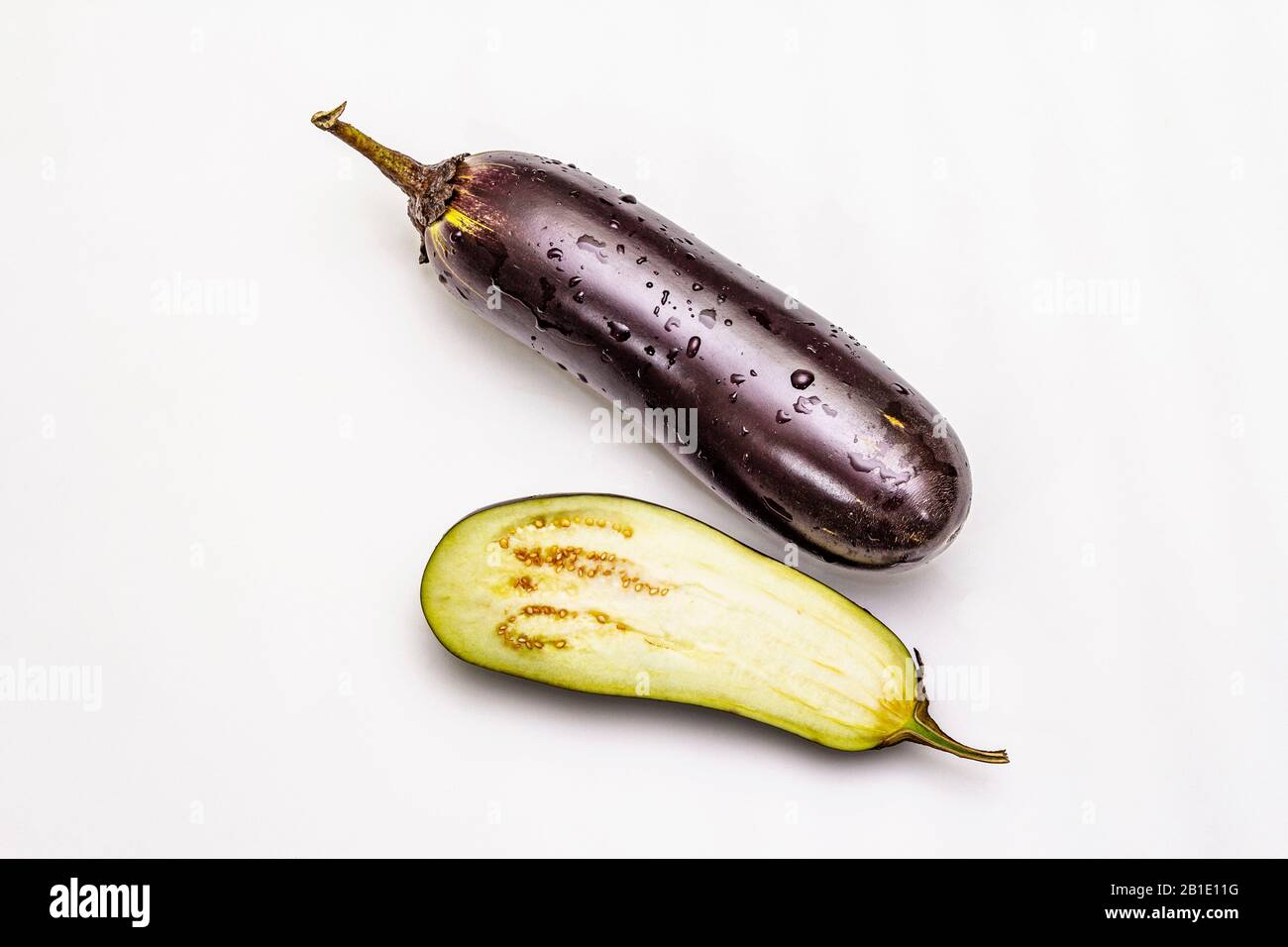 Ripe single eggplant. Fresh whole and half vegetable. Isolated on white ...