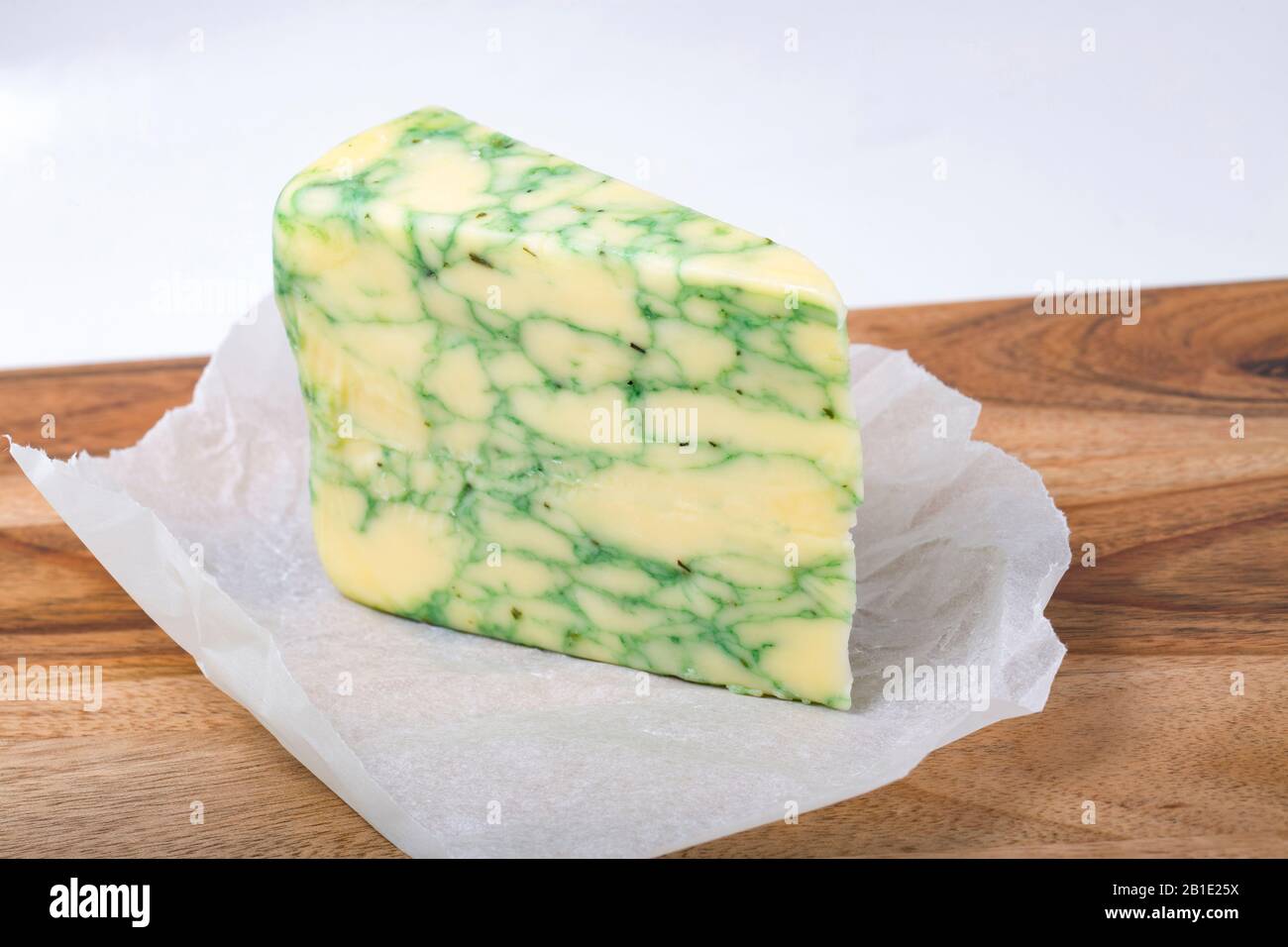 A wedge of Sage Derby cheese made with cow’s milk that has been ...