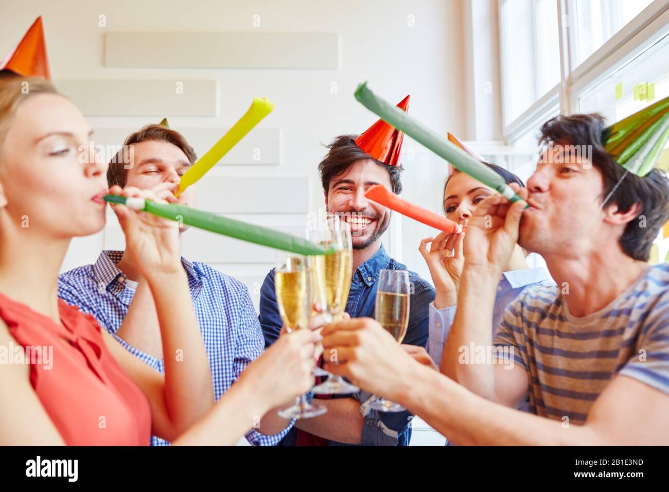 Successful team celebrates party as a group with sparkling wine and ...