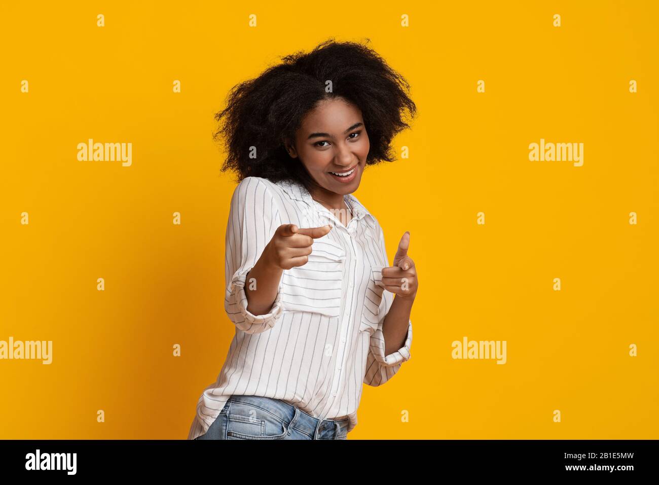 Gotcha. Positive african american woman pointing her index fingers at ...