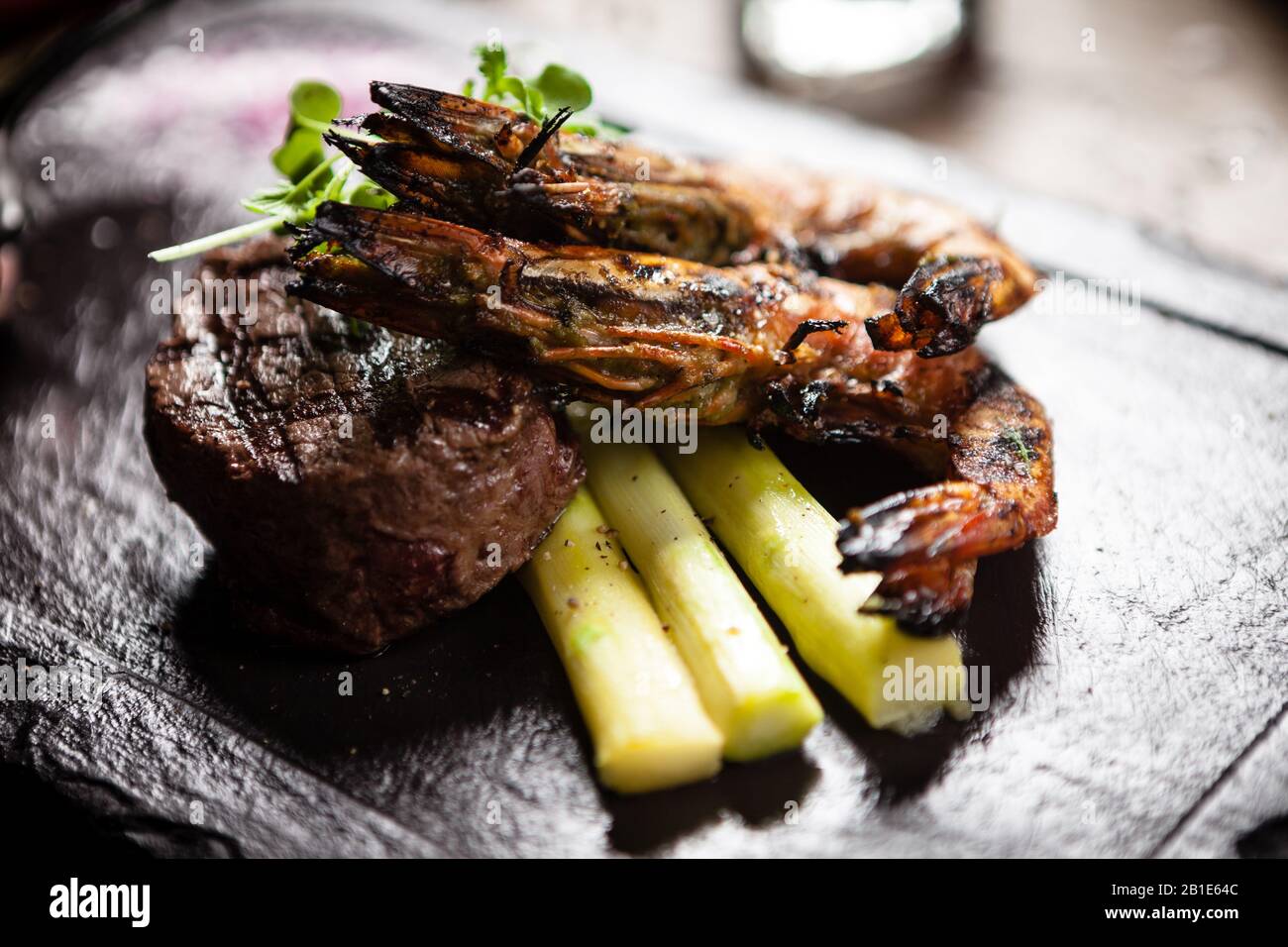 Tasting menu. Beef steak and grilled tiger prawns Stock Photo - Alamy