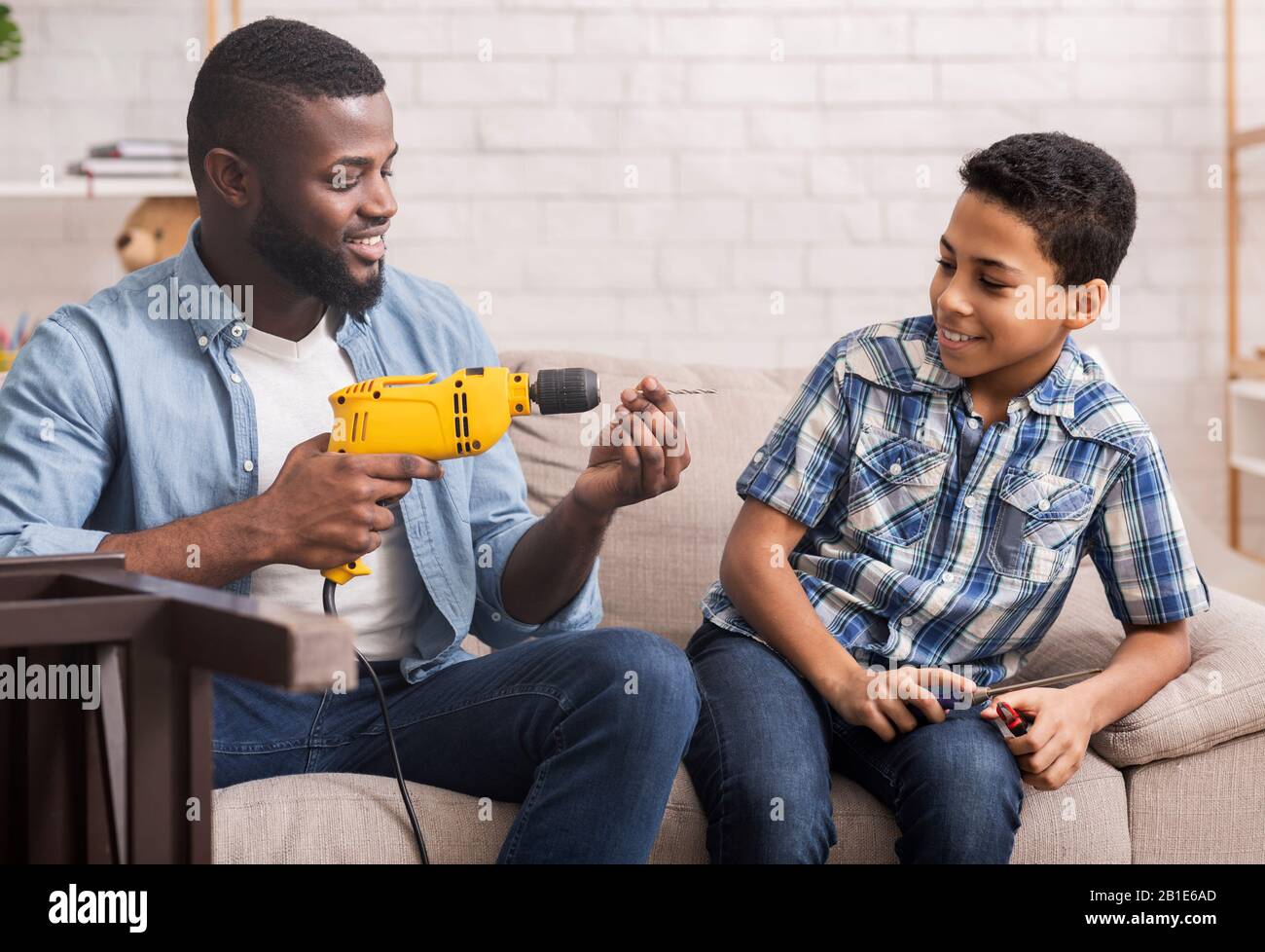 Happy Black Boy Learning From Father How To Use Electric Drill Stock ...