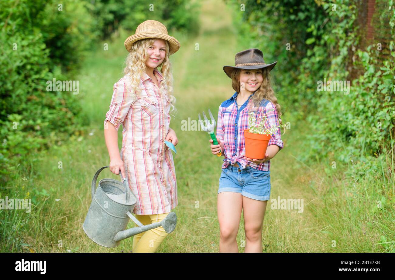 Agriculture concept. Girls in hats planting plants. Sisters helping at ...