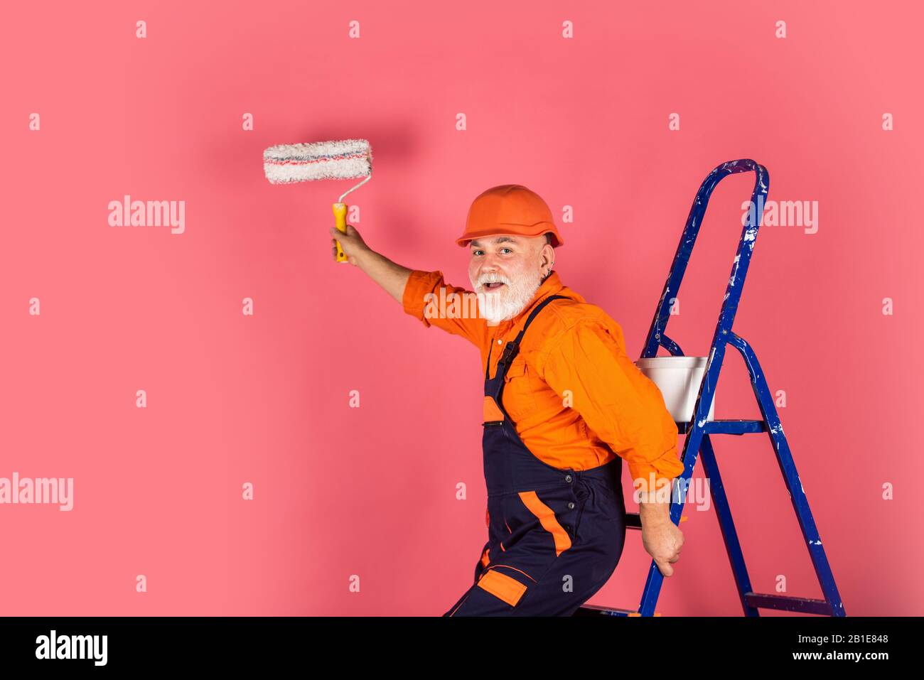 exploring tools. senior man painter use roller on ladder. painting the ...
