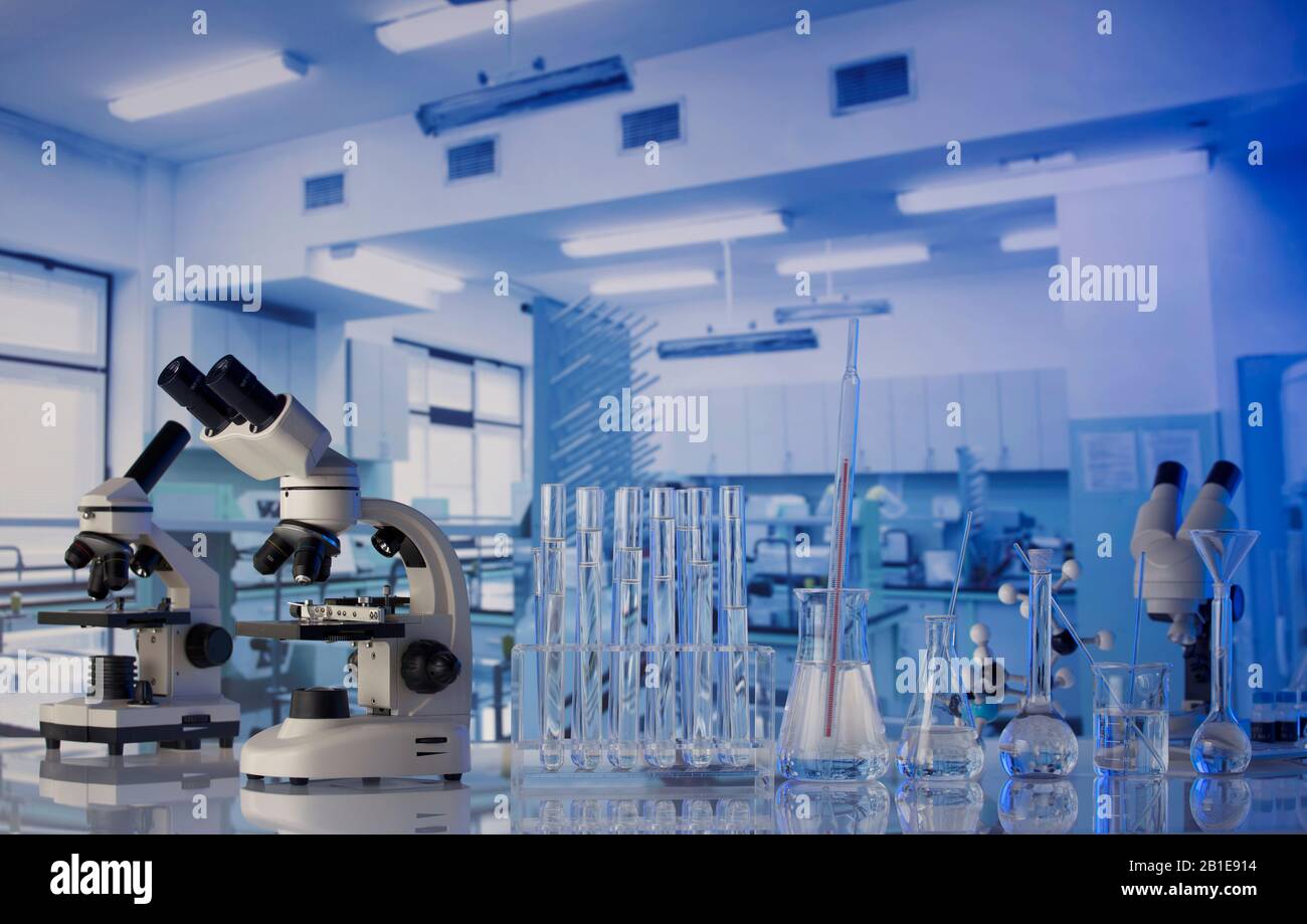 Science laboratory. Beakers, test-tubes and microscope on glass table ...