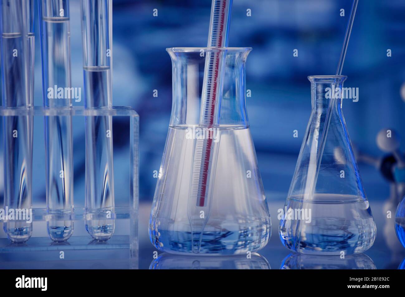 Science laboratory. Beakers, test-tubes and microscope on glass table ...