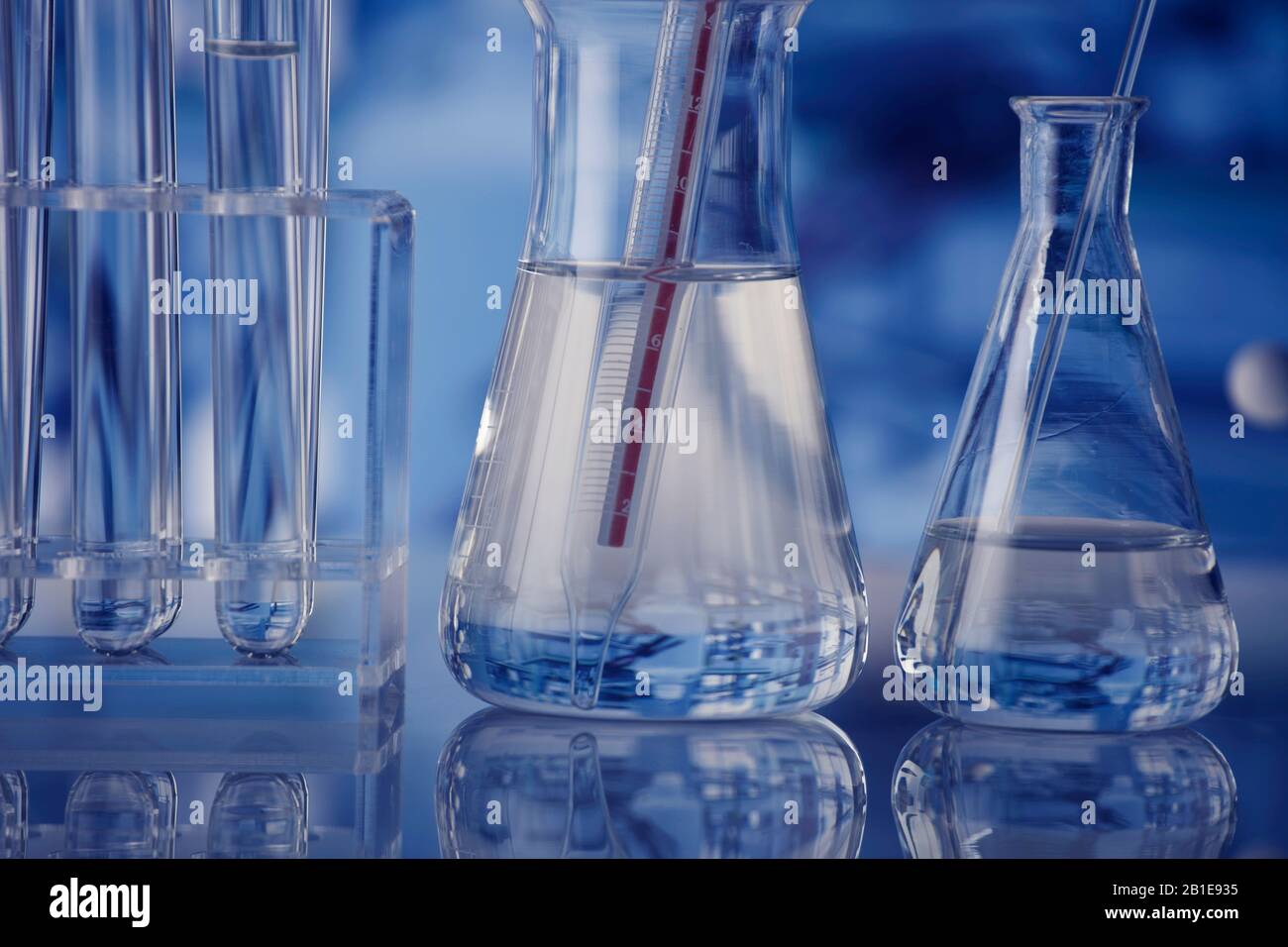 Science laboratory. Beakers, test-tubes and microscope on glass table ...