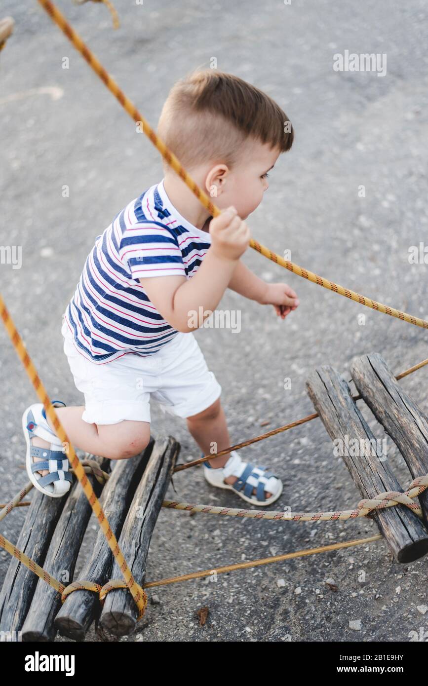 a little boy plays in a rope town, and overcomes an obstacle Stock ...