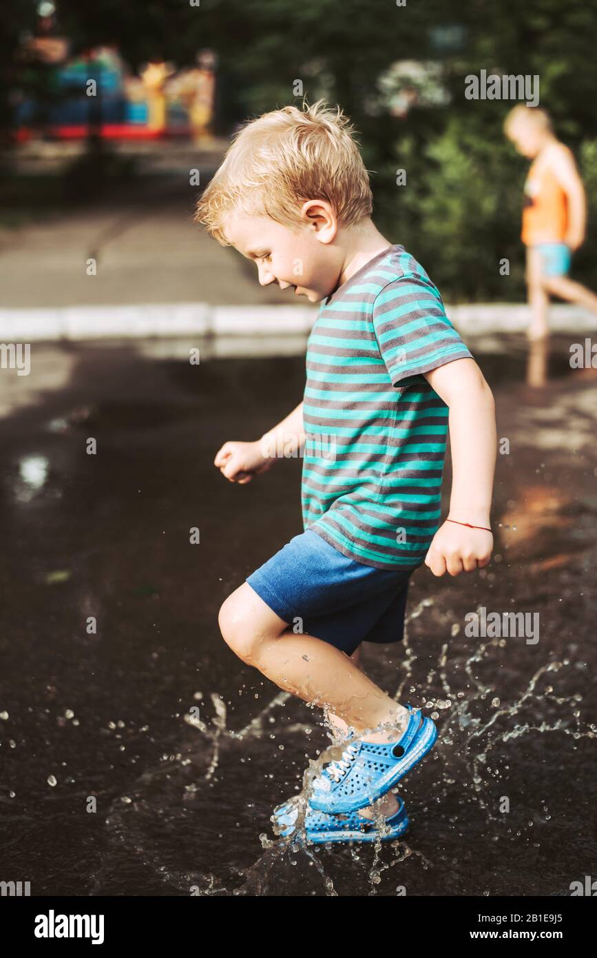 Kid jumping in a mud puddle hi-res stock photography and images - Alamy