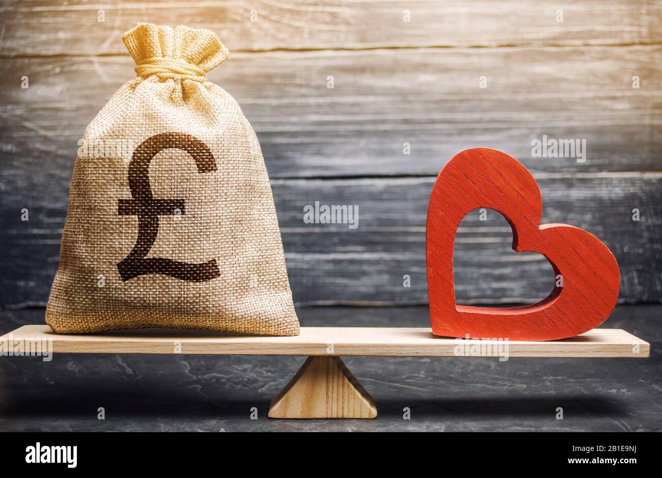Money bag and red wooden heart on the scales. Money versus love concept ...