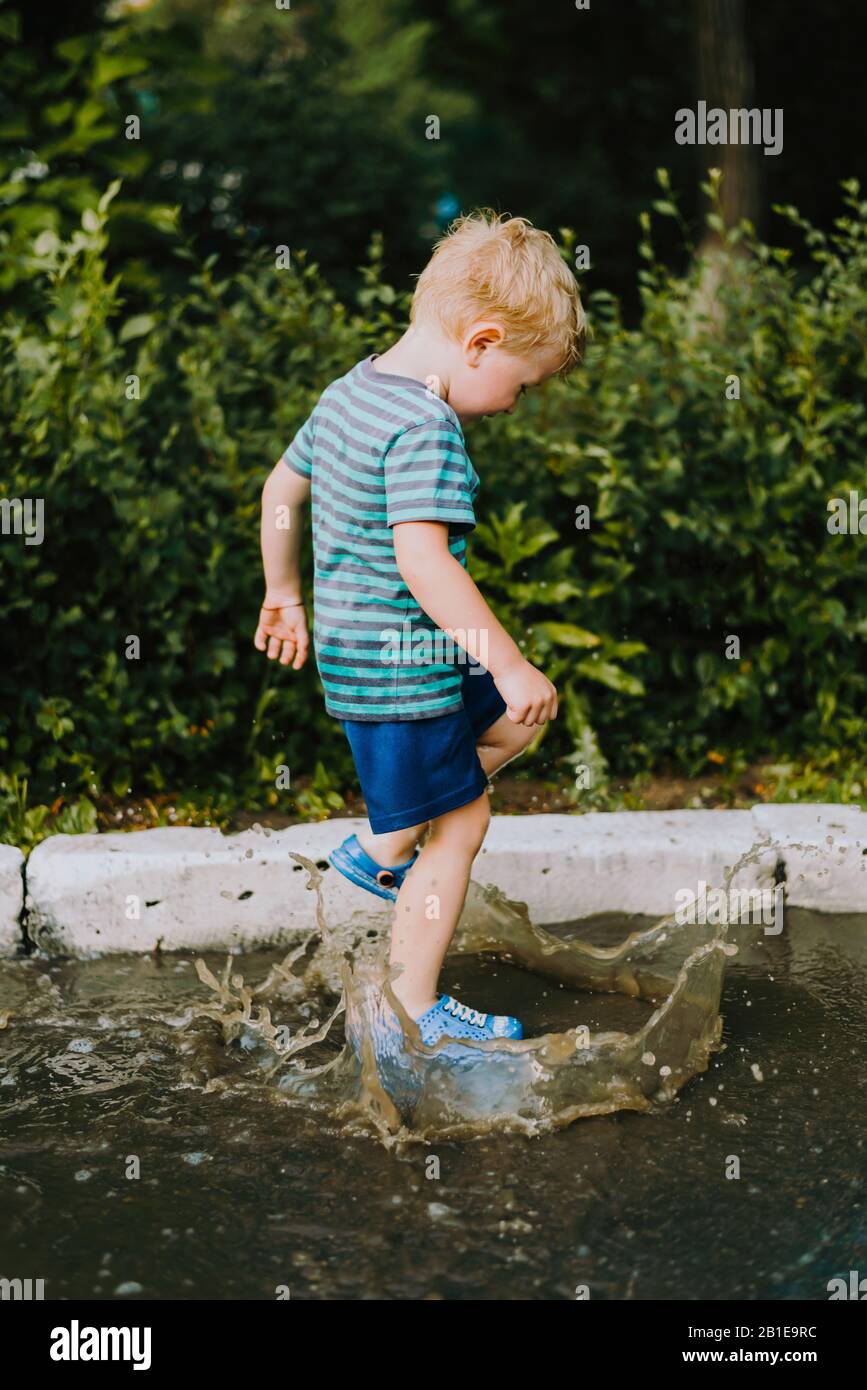 Kid jumping in a mud puddle hi-res stock photography and images - Alamy