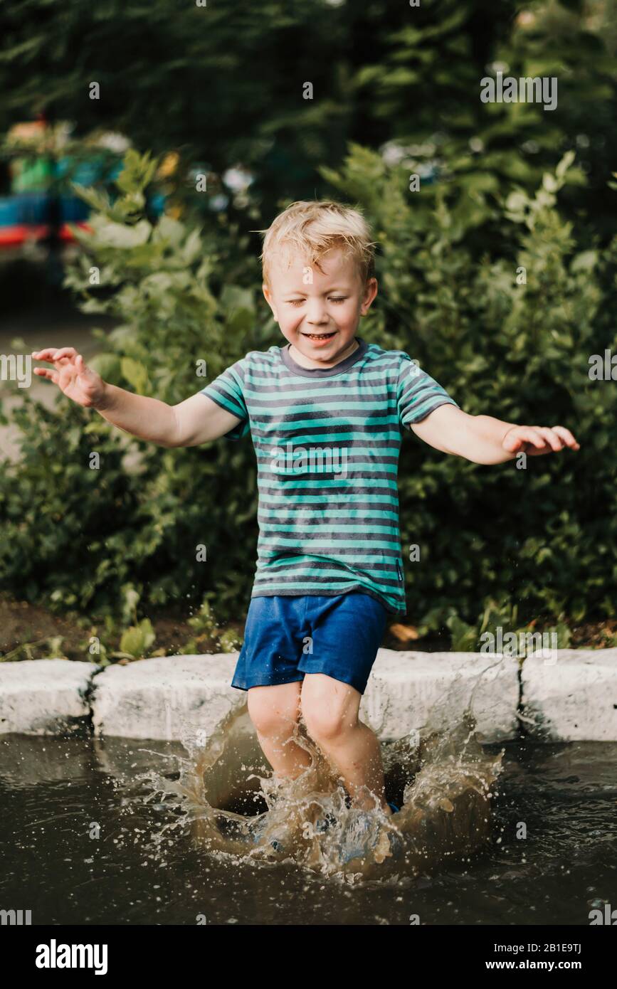 Kid jumping in a mud puddle hi-res stock photography and images - Alamy