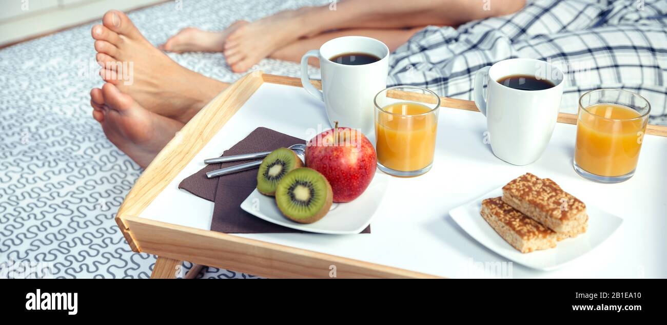 Healthy breakfast on tray and couple legs in background Stock Photo - Alamy