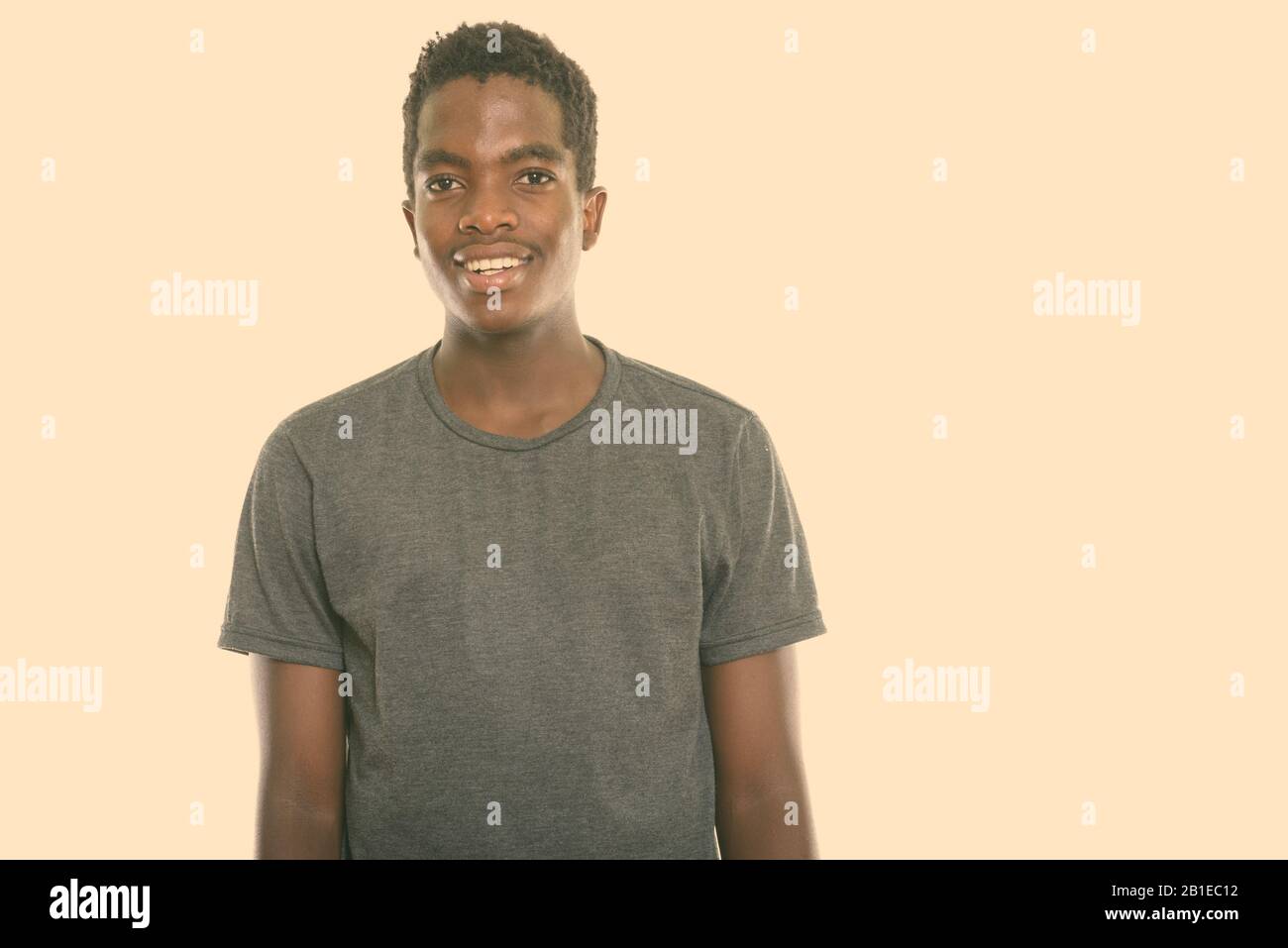 Studio shot of young happy black African teenage boy smiling from ...