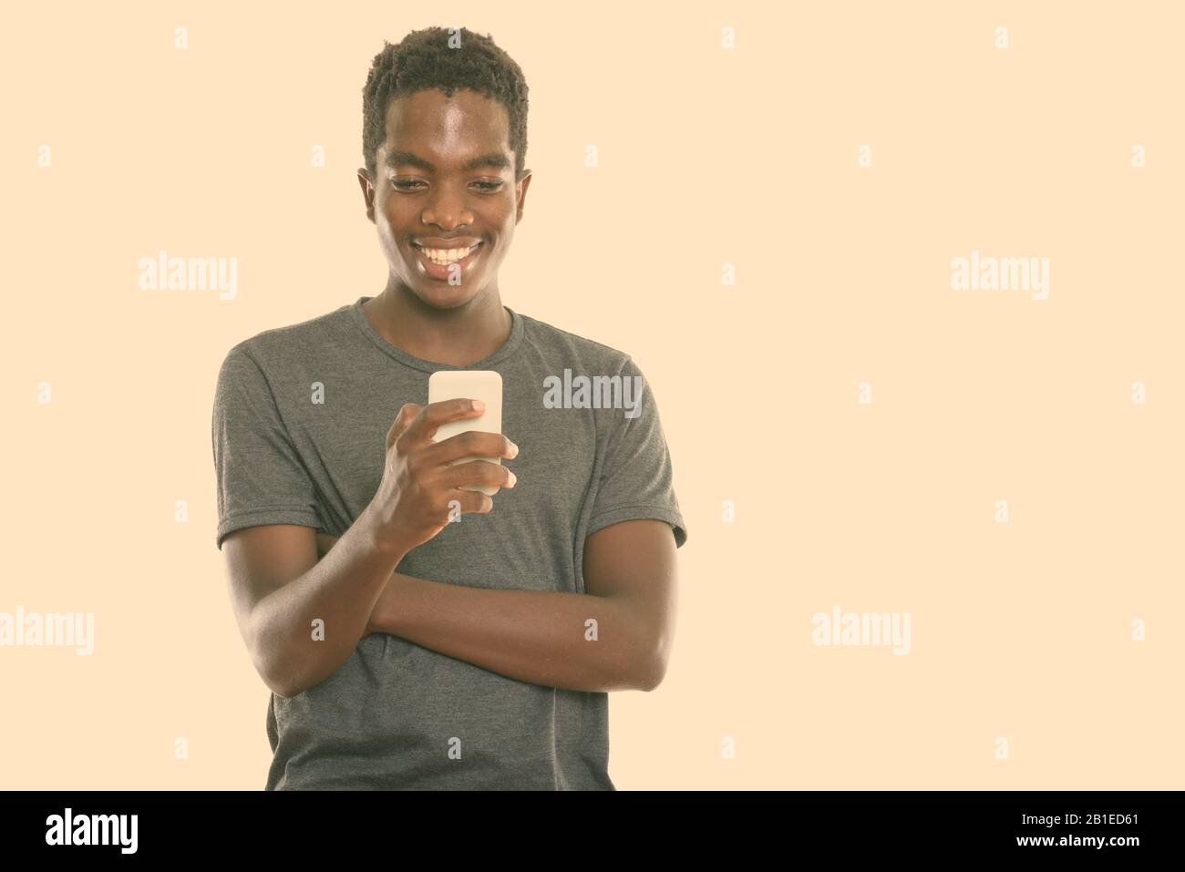 Studio shot of young happy black African teenage boy smiling while ...