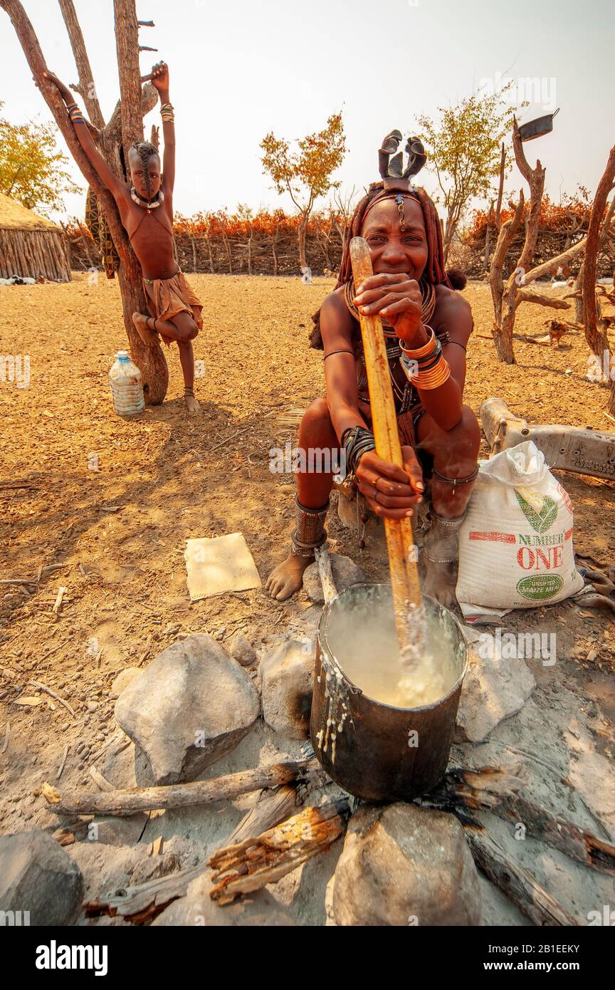 Himba woman cooking their staples food made with corn meal at his ...