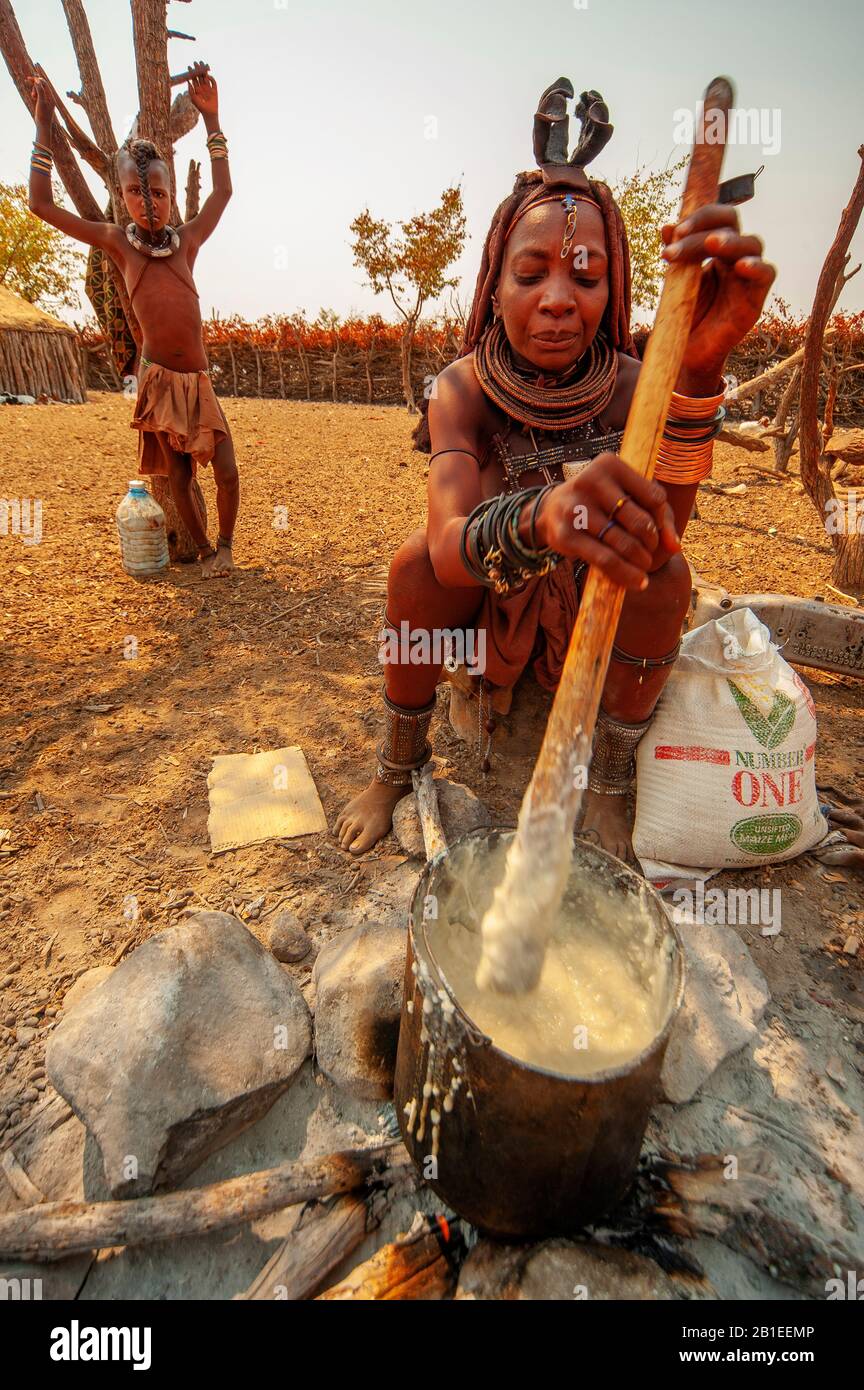 Himba woman cooking their staples food made with corn meal at his ...