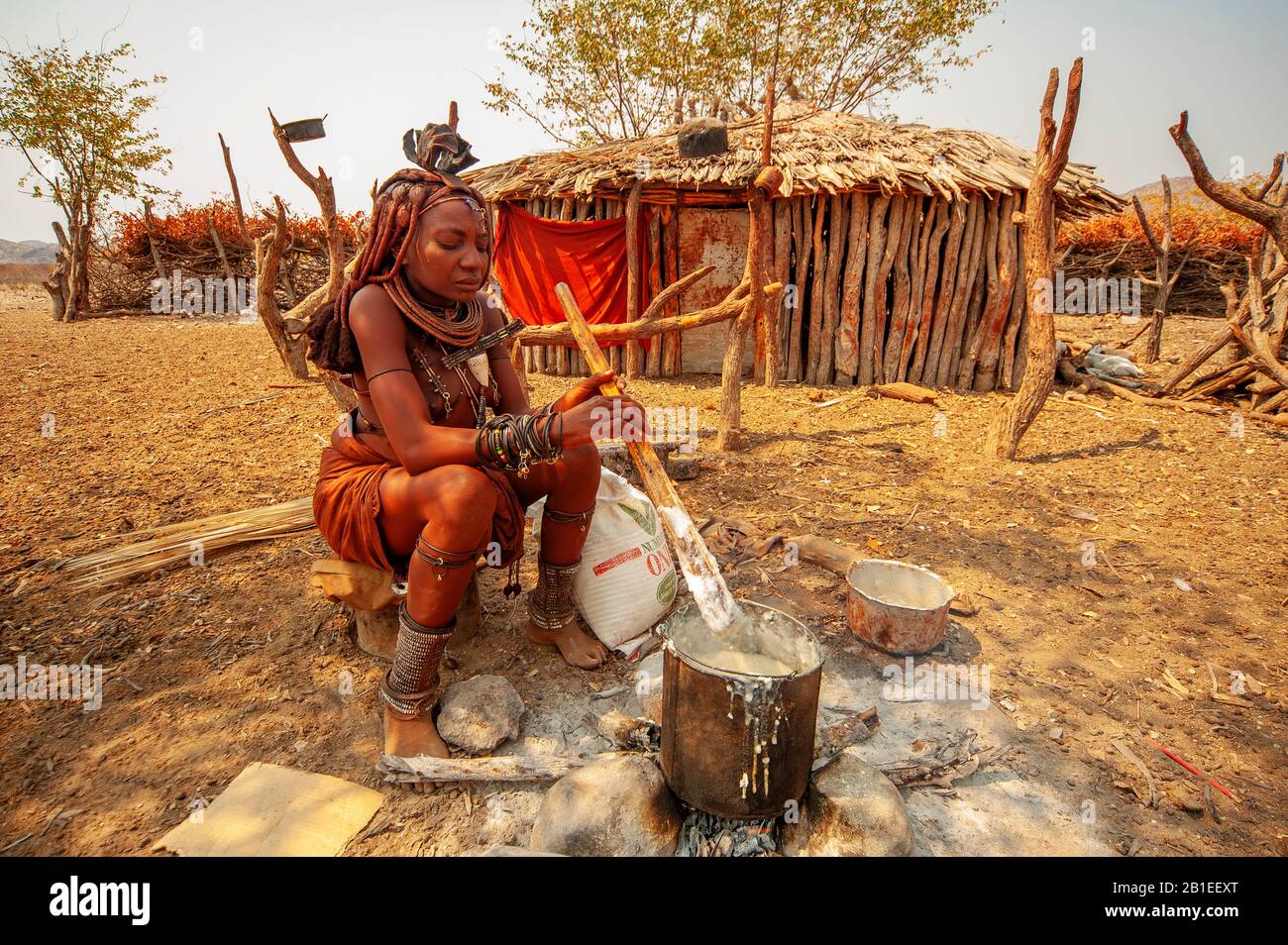 Himba woman cooking their staples food made with corn meal at his ...