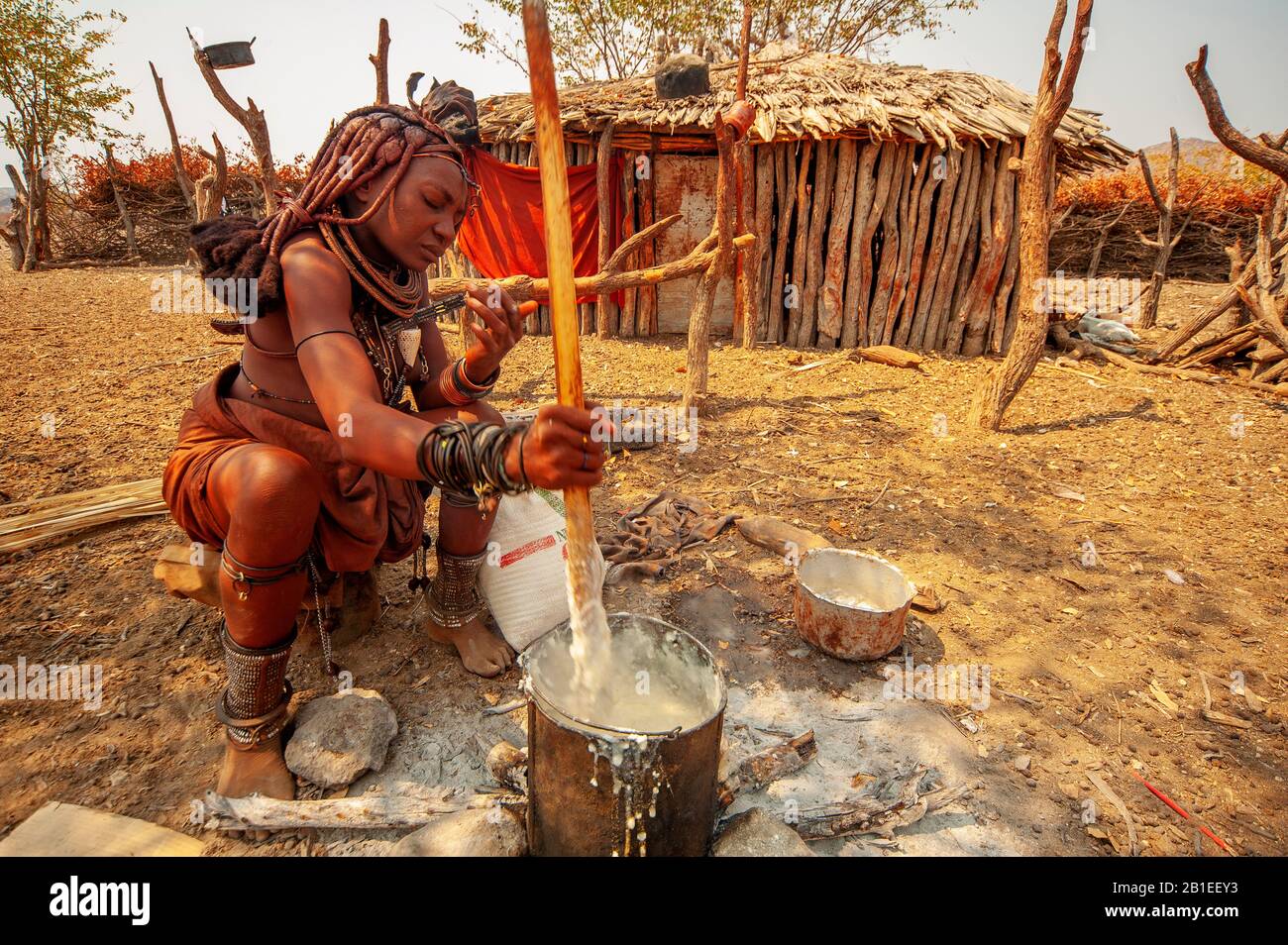 Himba woman cooking their staples food made with corn meal at his ...