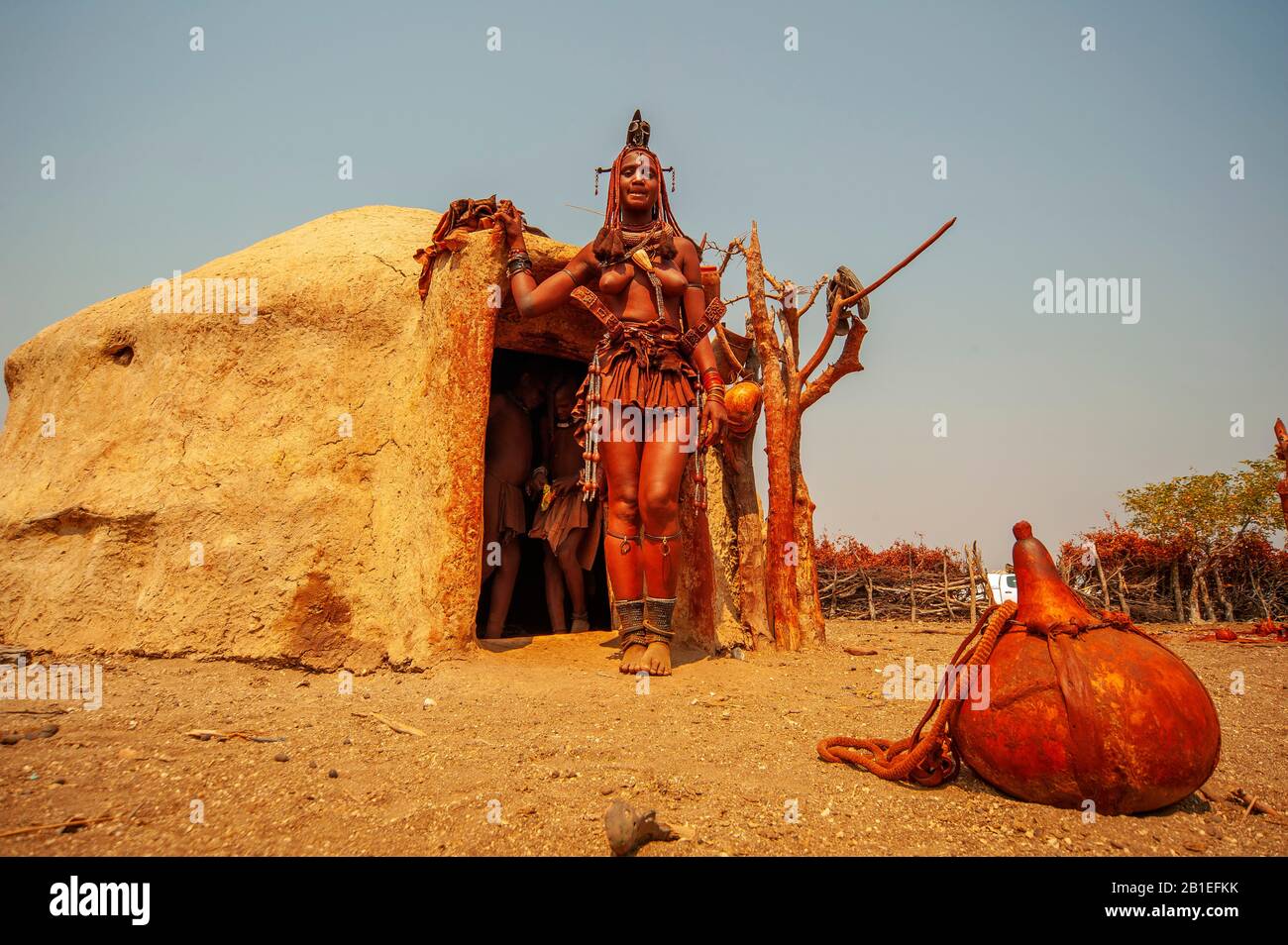 Himba woman wearing traditional clothes with his kids in front of their ...